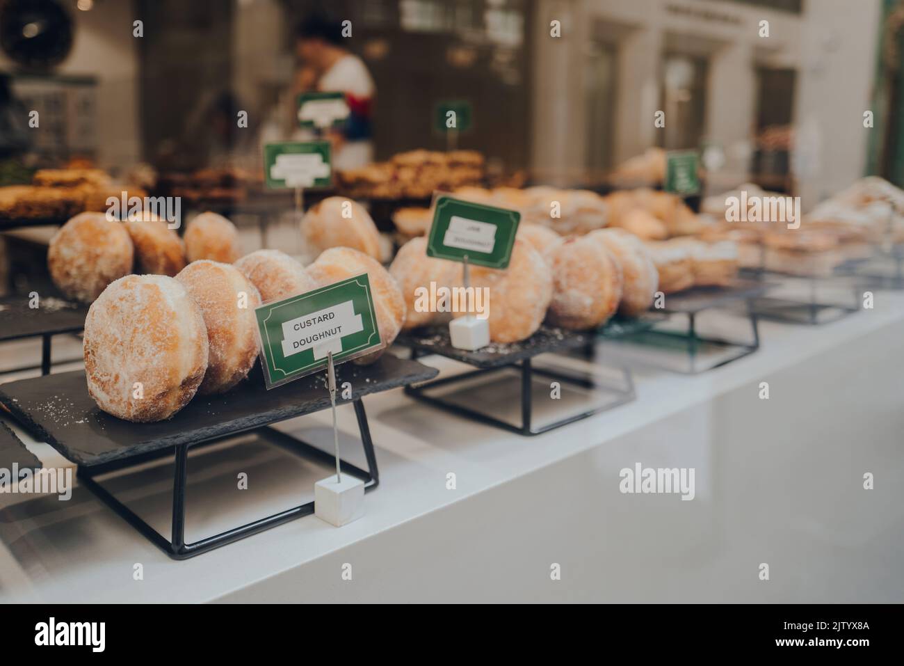 Close of up of a variety of doughnuts on a window display of a cafe in ...