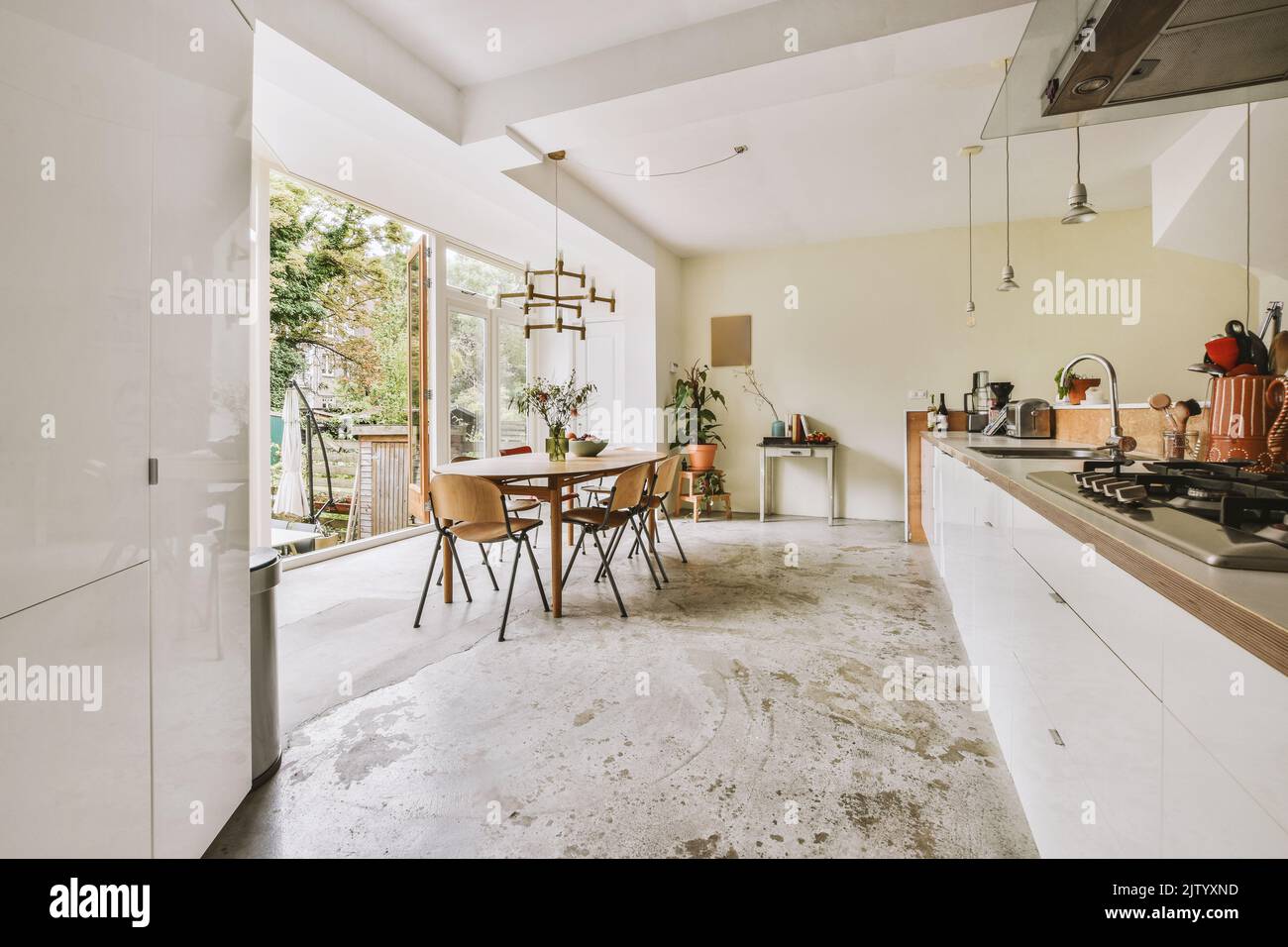 Interior of light kitchen and dining room with balcony doors in ...