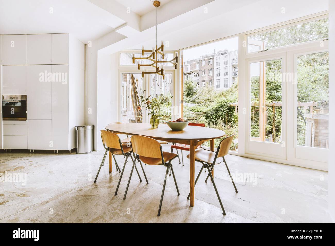Interior of light kitchen and dining room with balcony doors in ...