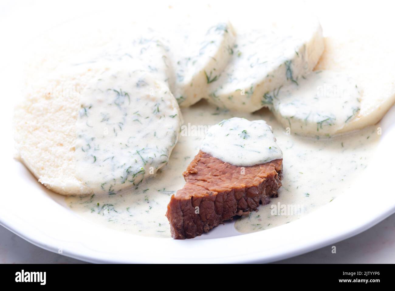 beef meat with dill sauce and dumplings Stock Photo - Alamy