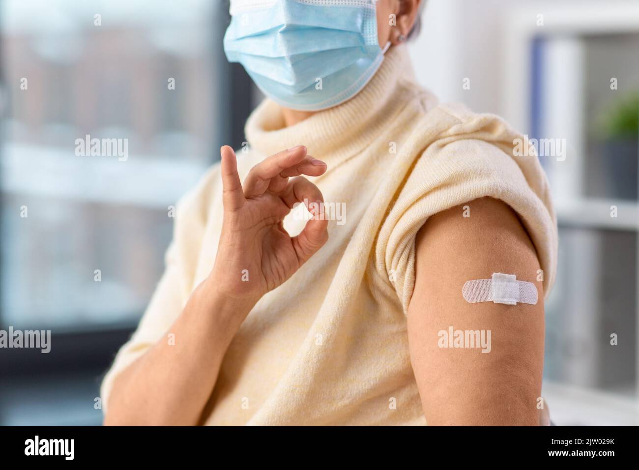vaccinated senior woman with medical patch on arm Stock Photo - Alamy