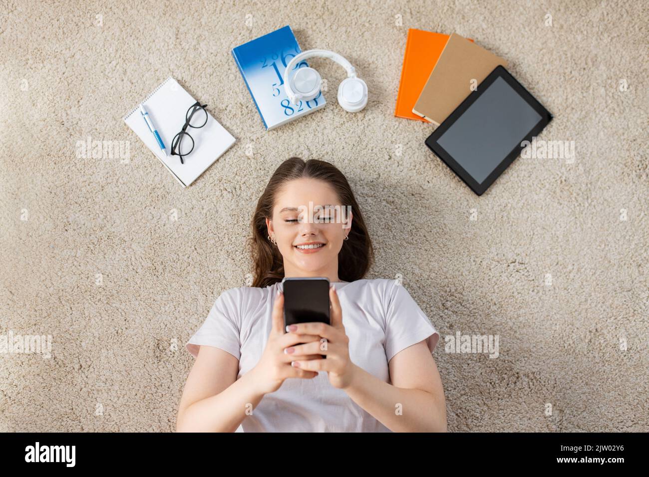 happy student girl with books and gadgets on floor Stock Photo - Alamy