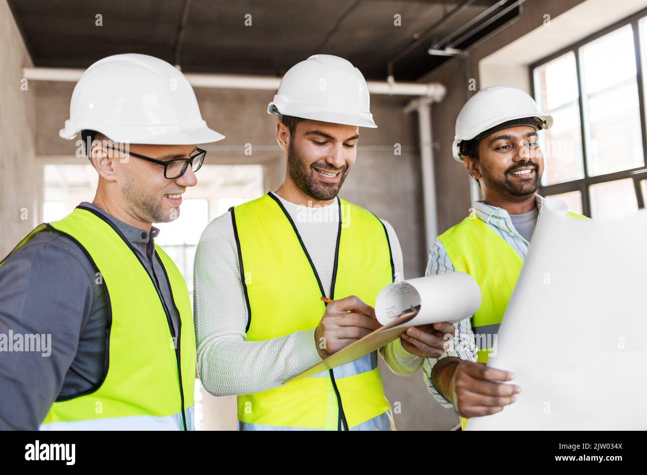architects in helmets with blueprint at office Stock Photo - Alamy