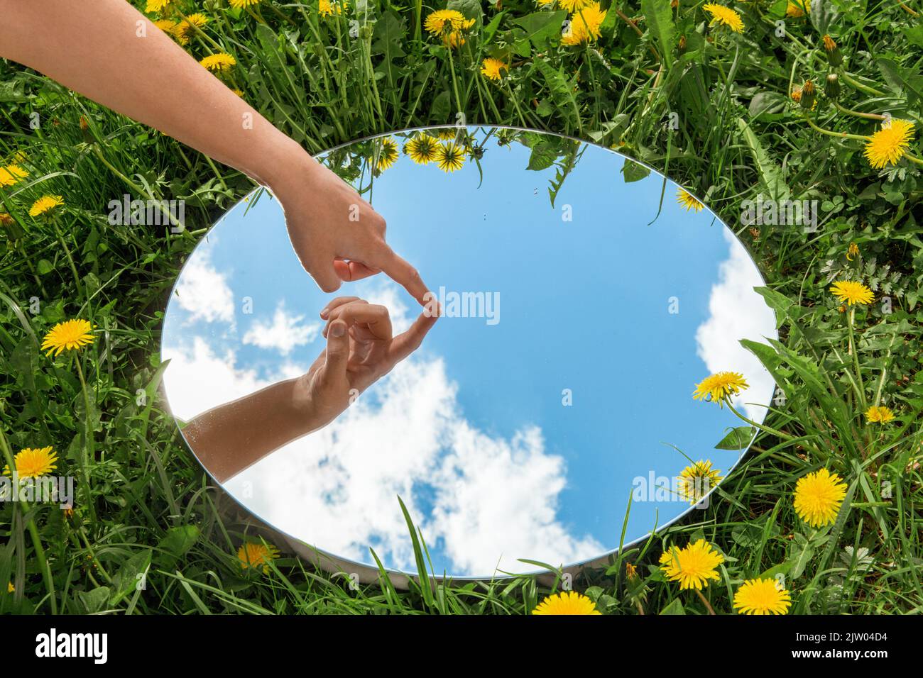 hand touching sky reflection in mirror on field Stock Photo - Alamy
