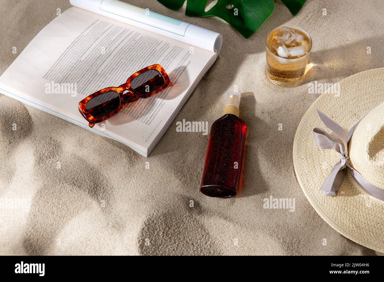 magazine, sunglasses and sunscreen on beach sand Stock Photo - Alamy