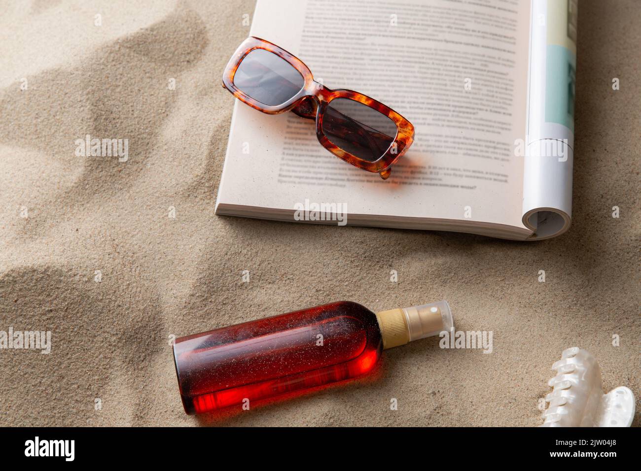 magazine, sunglasses and sunscreen on beach sand Stock Photo - Alamy
