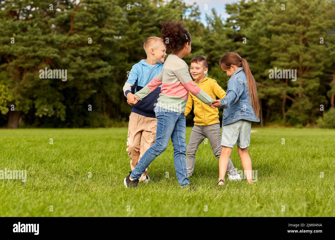 happy children playing round dance at park Stock Photo - Alamy
