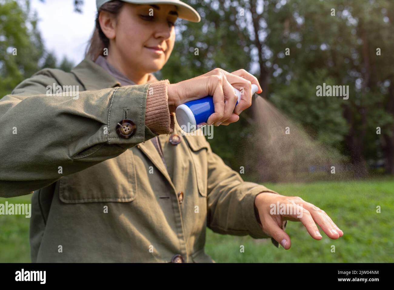 woman spraying insect repellent to hand at park Stock Photo - Alamy