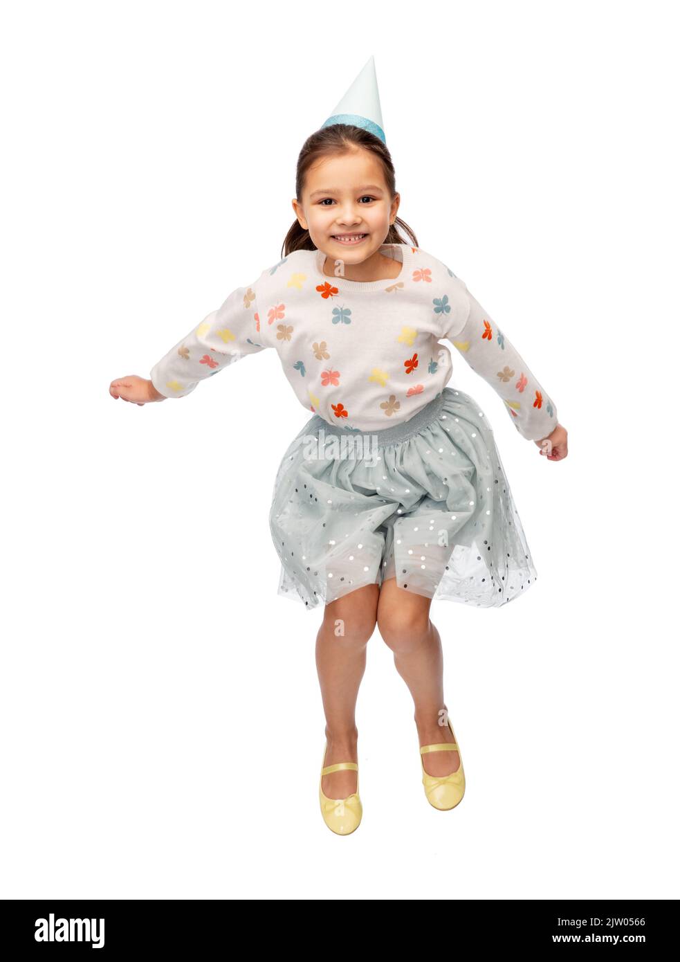 smiling little girl in birthday party hat jumping Stock Photo - Alamy