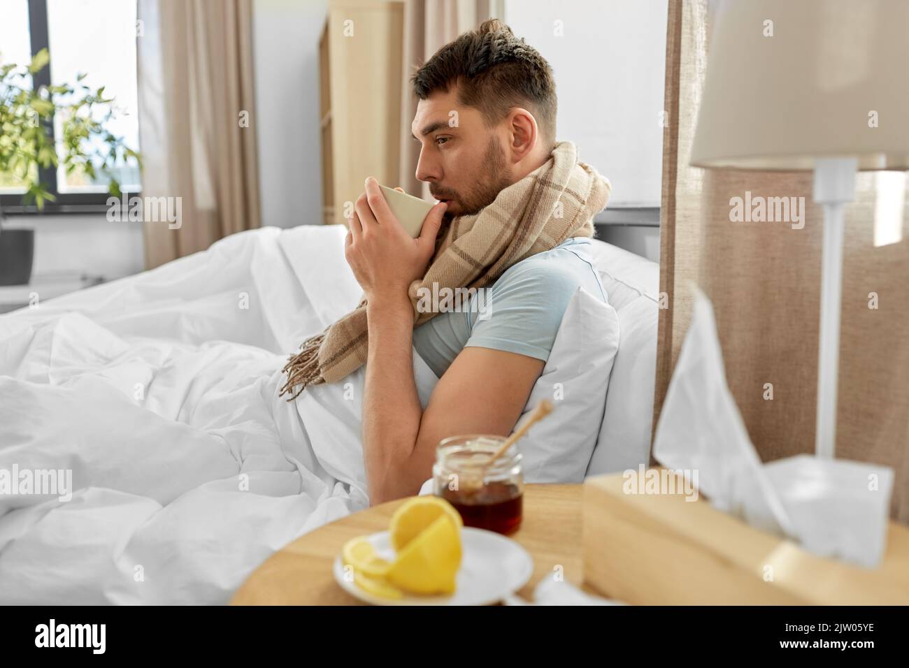sick man drinking hot tea in bed at home Stock Photo - Alamy