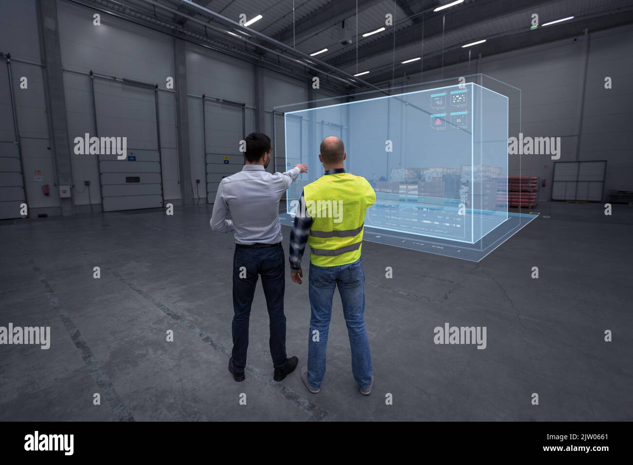 man showing virtual hologram to warehouse worker Stock Photo - Alamy