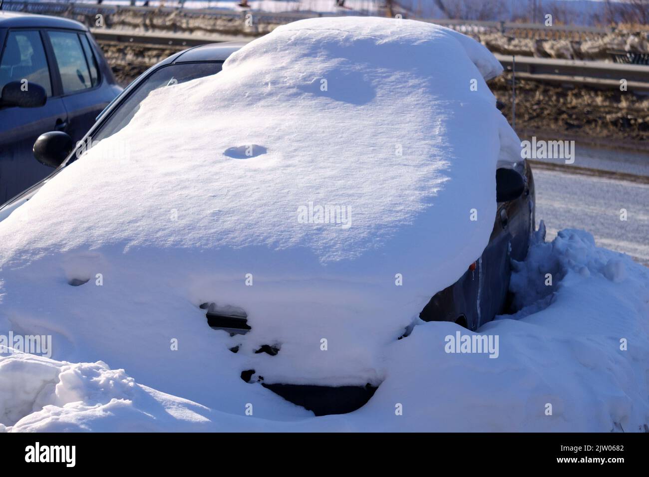 Vehicles are completely covered in snow. Cold winter weather. Blizzard ...