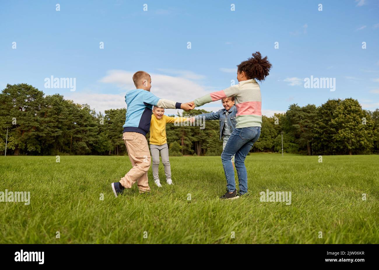 happy children playing round dance at park Stock Photo - Alamy
