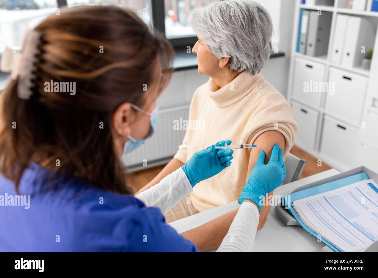nurse with syringe making injection to woman Stock Photo - Alamy
