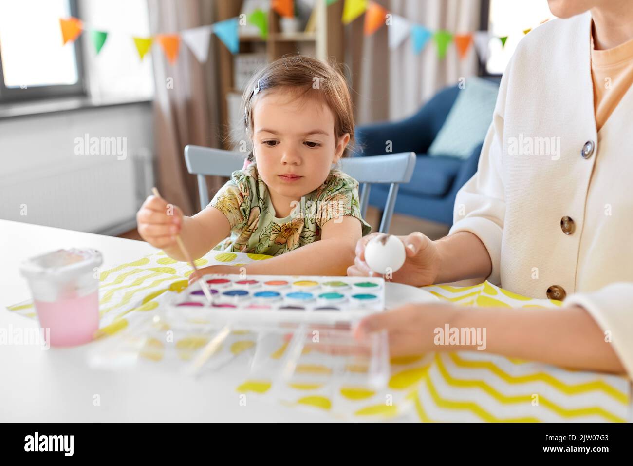 mother with child coloring easter eggs at home Stock Photo - Alamy
