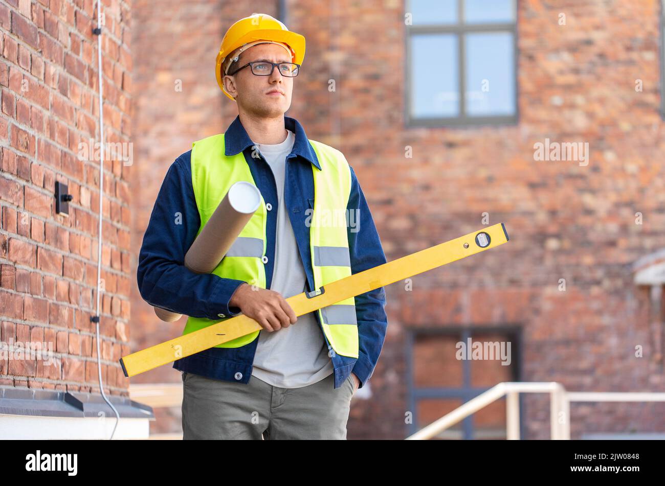 male architect in helmet with level on site Stock Photo - Alamy