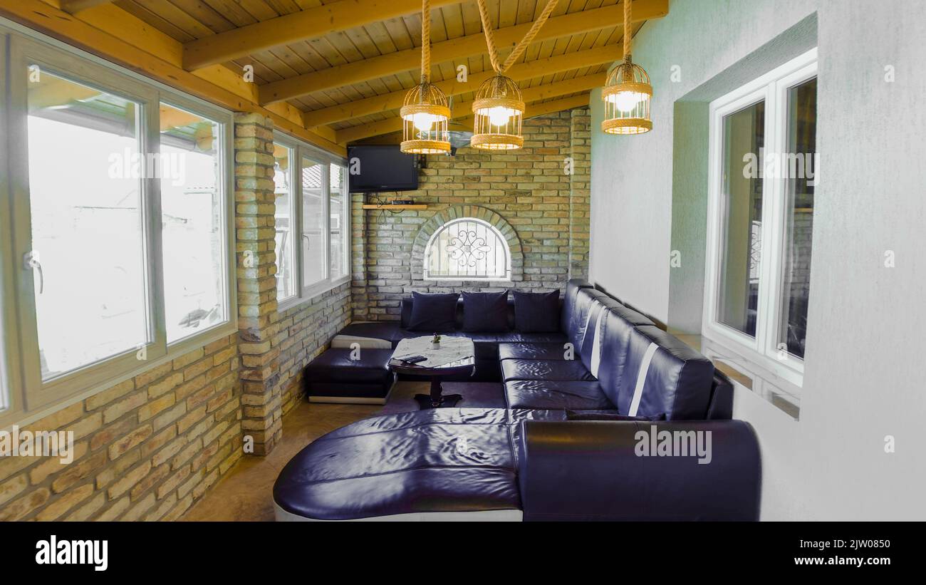 Indoor terrace area with a big leather sofa Stock Photo - Alamy