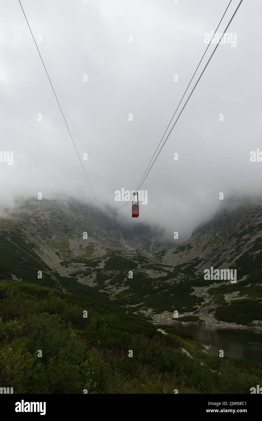 Cable car disappearing into the clouds on its journey to Lomnicky Stit ...