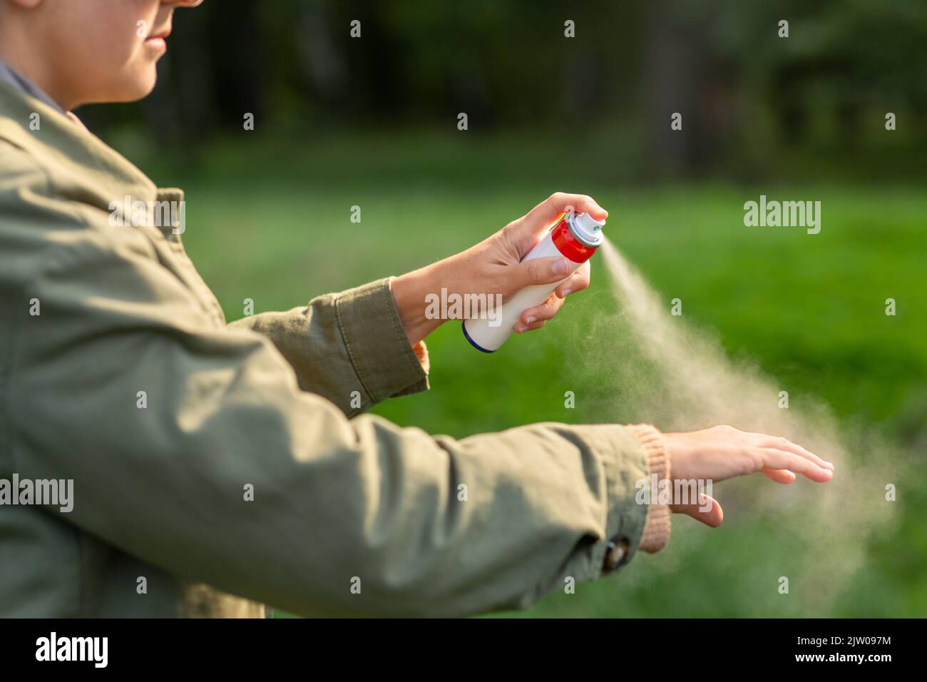 woman spraying insect repellent to hand at park Stock Photo - Alamy
