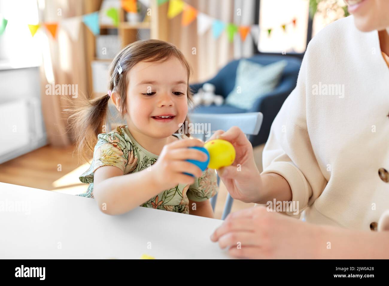 baby girl and mother tapping easter eggs at home Stock Photo - Alamy