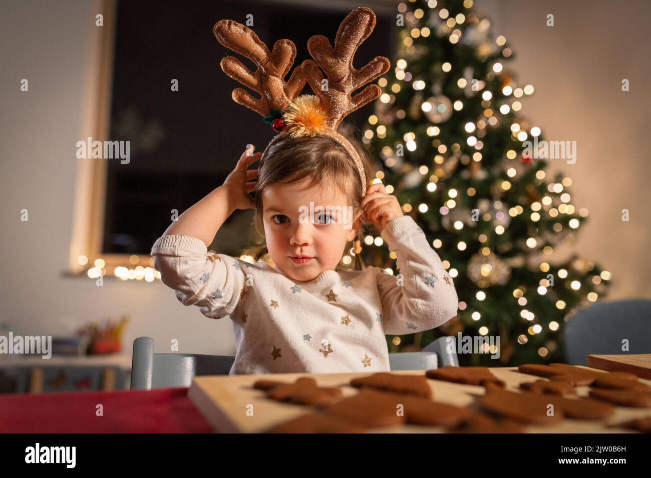 little girl with reindeer horns tiara on christmas Stock Photo - Alamy