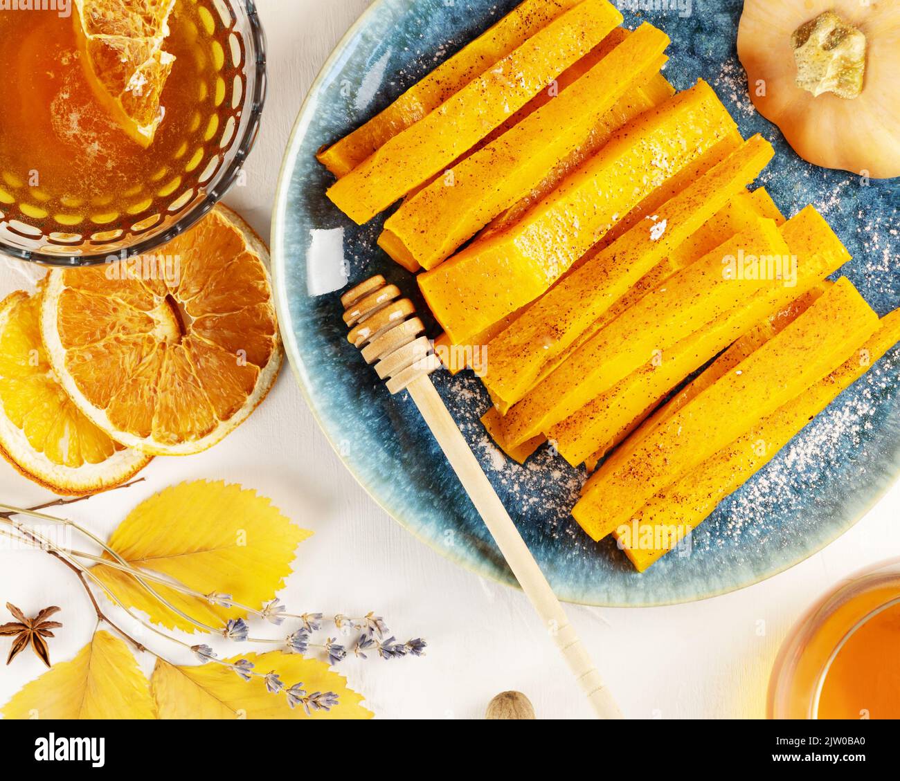 Baked pumpkin slices with cinnamon, honey and dried oranges with herbal ...