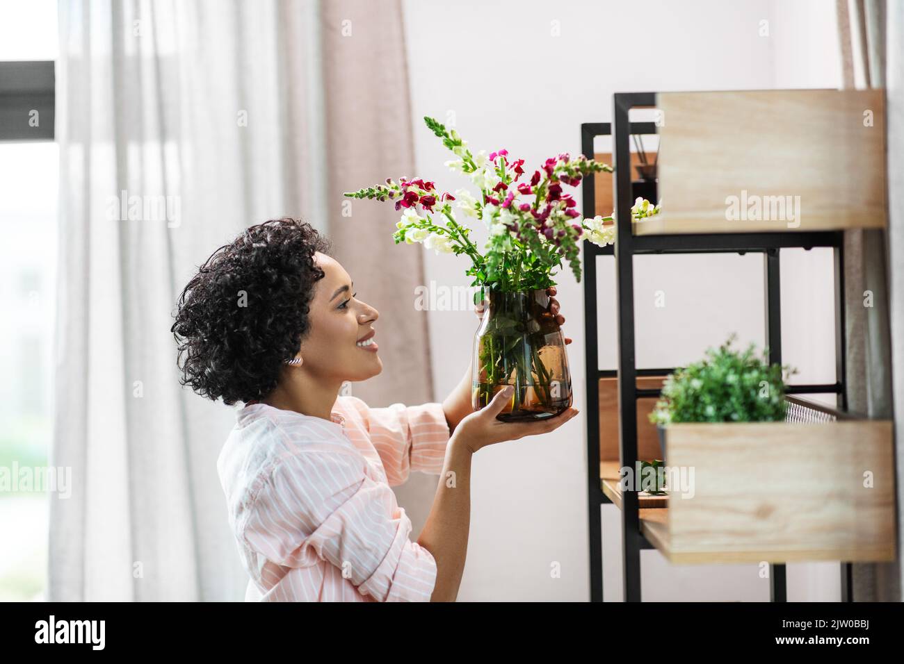 Woman putting flowers on shelving hi-res stock photography and images ...