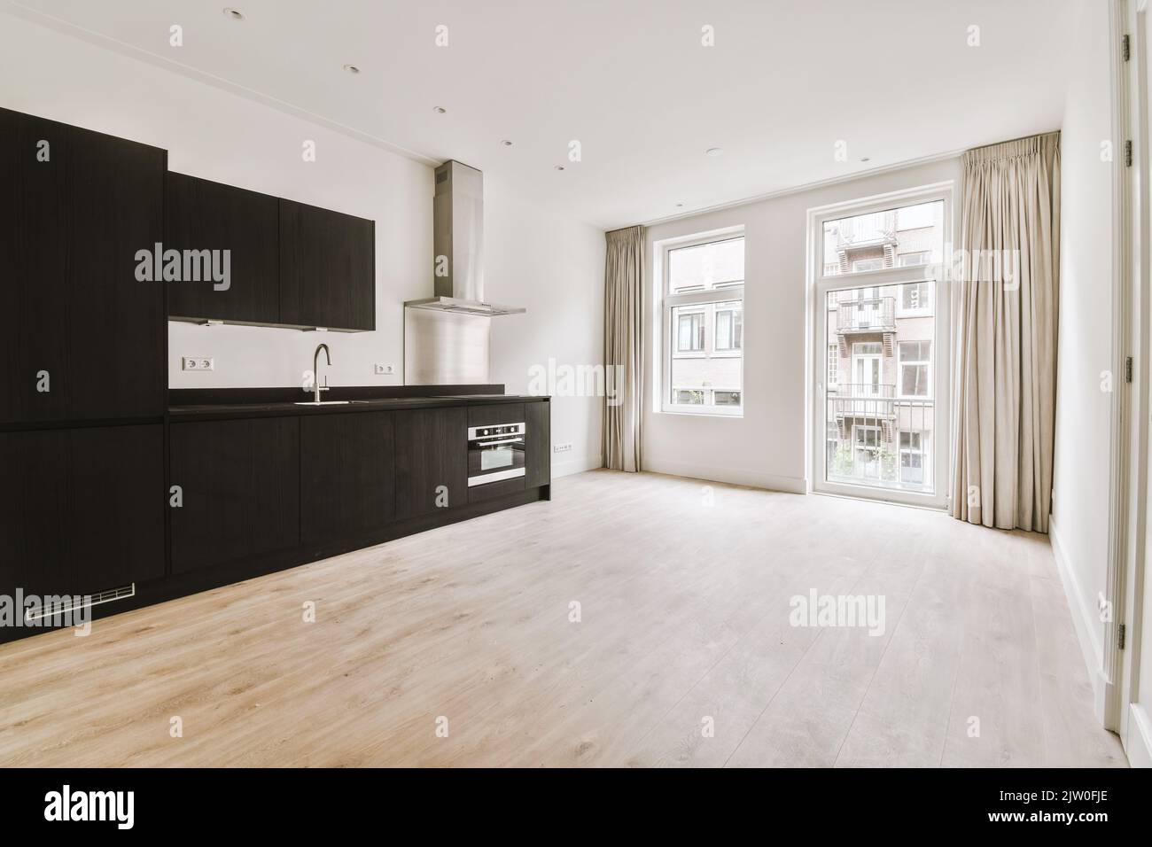 Interior of empty white kitchen with windows and wooden parquet floor ...