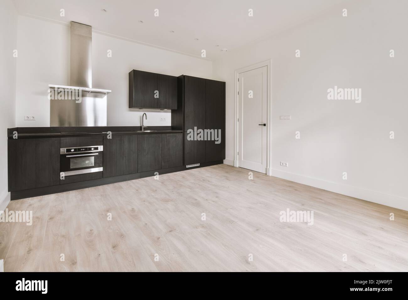 Interior of empty white kitchen with windows and wooden parquet floor ...