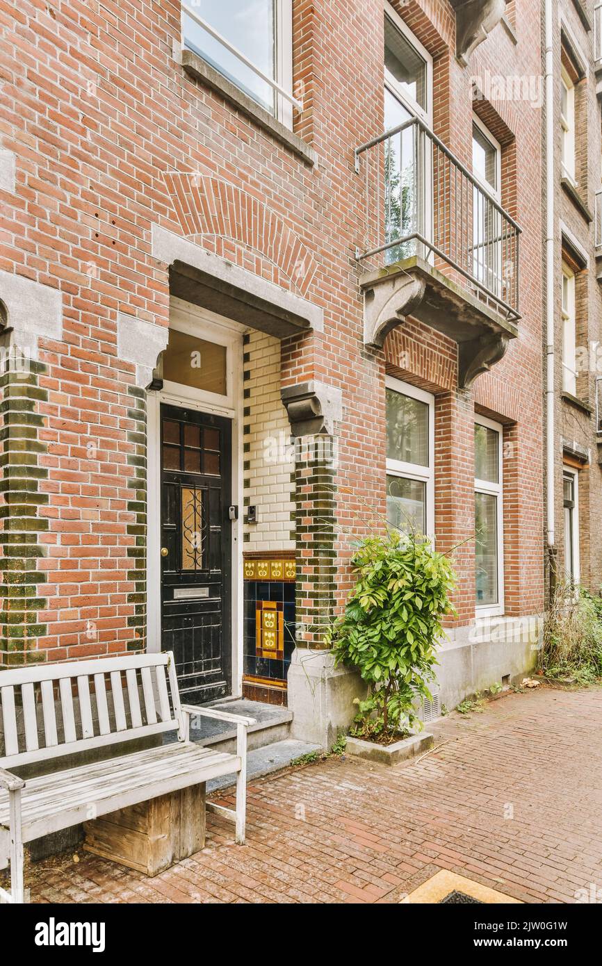 The front view of a brick building with signs, pavement and wooden ...