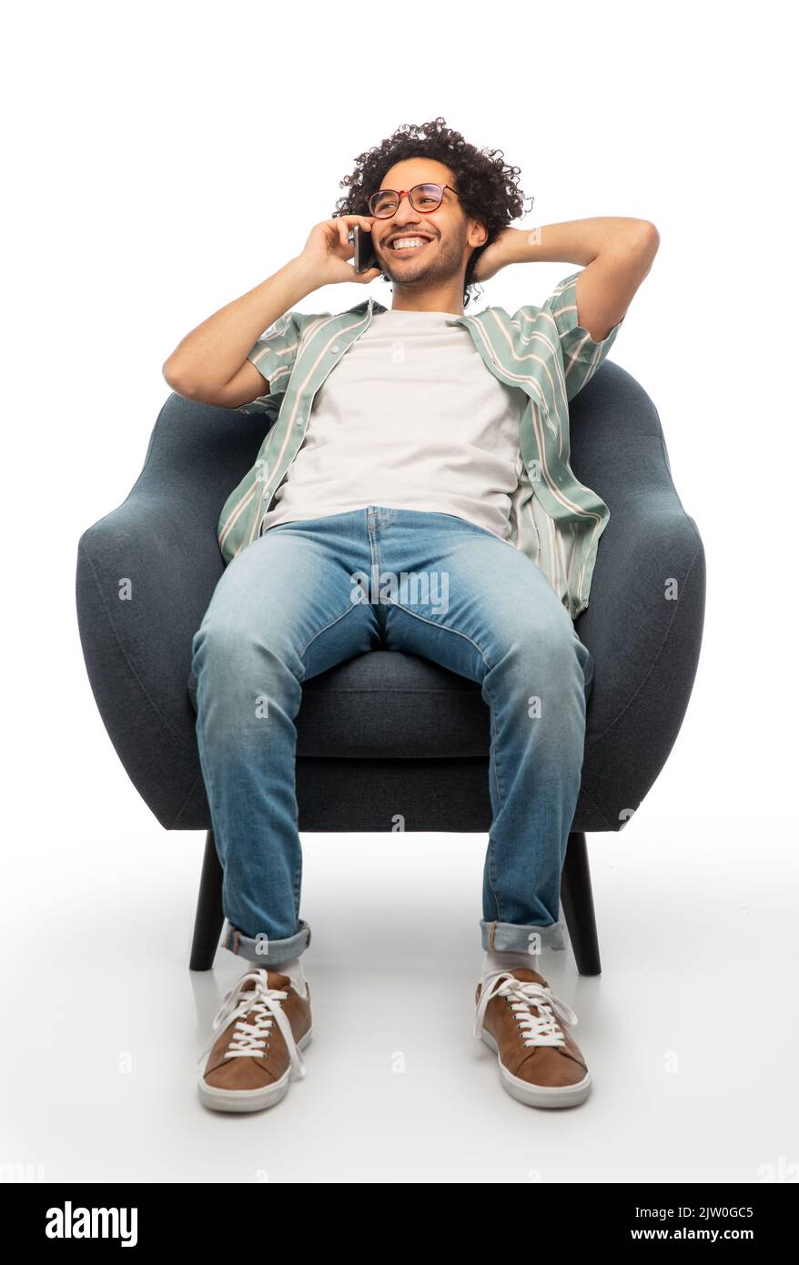 smiling man sitting in chair calling on smartphone Stock Photo - Alamy