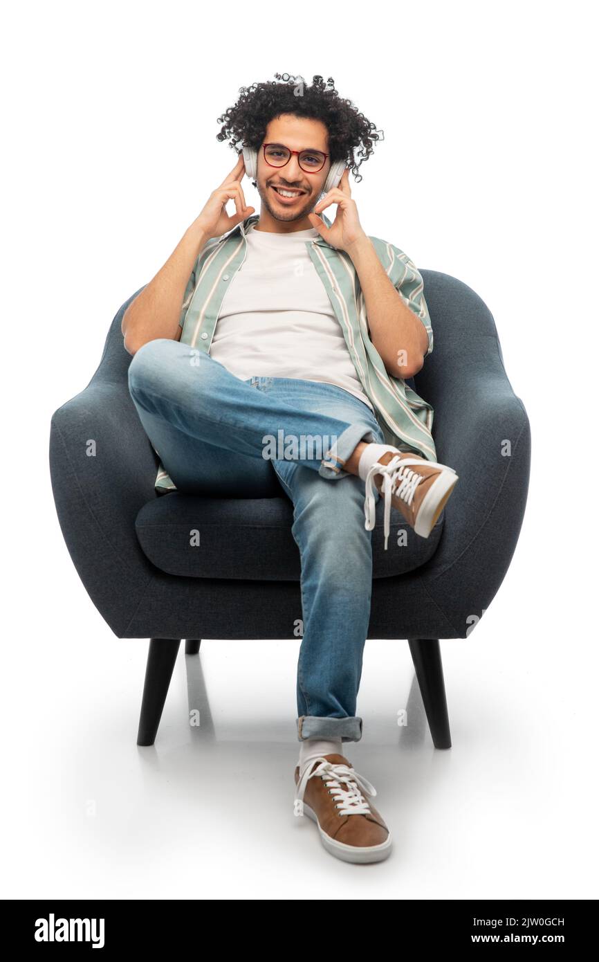 man in headphones listening to music in chair Stock Photo - Alamy