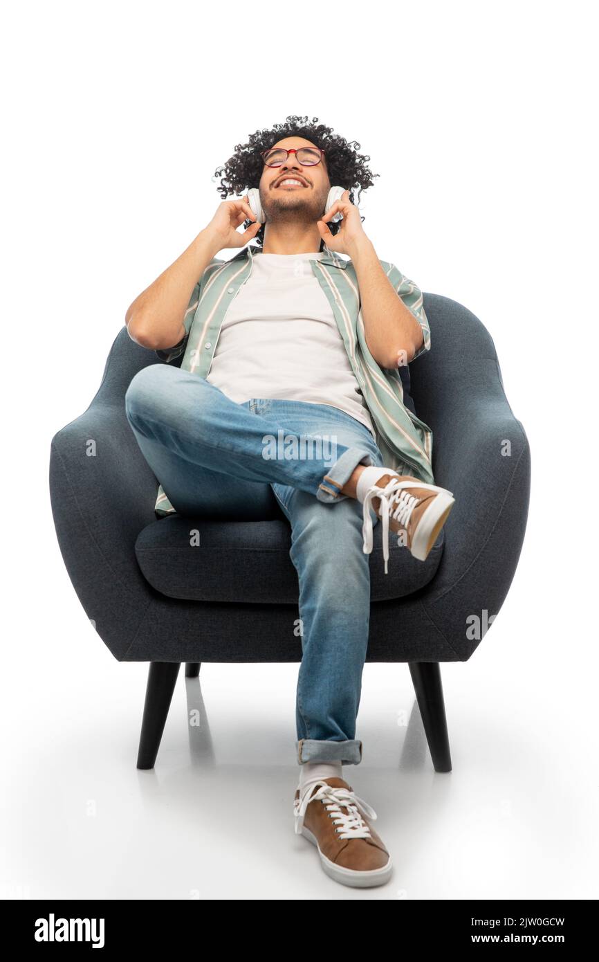 man in headphones listening to music in chair Stock Photo - Alamy
