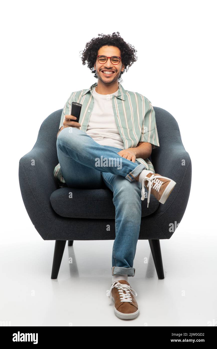 happy man with tv remote control sitting in chair Stock Photo - Alamy