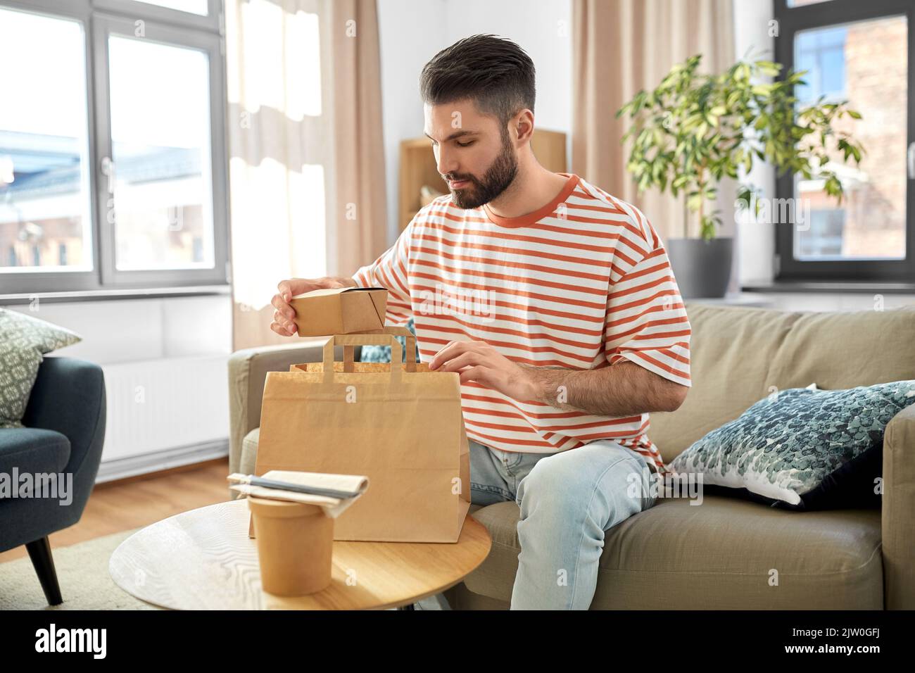 man unpacking takeaway food at home Stock Photo - Alamy