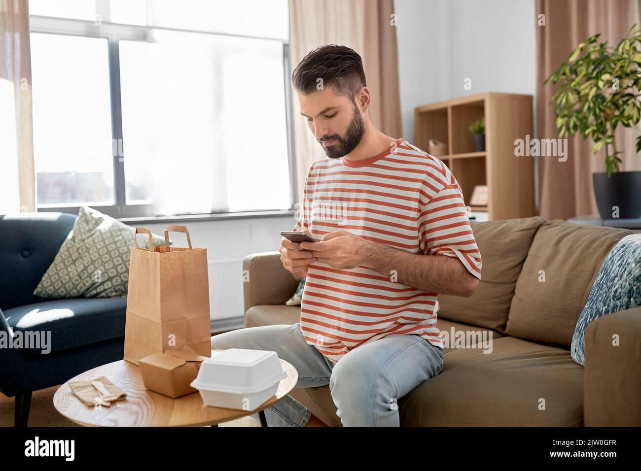 man with phone checking food order at home Stock Photo - Alamy