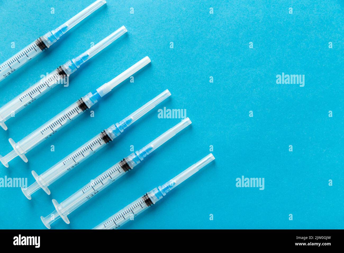 disposable syringes on blue background Stock Photo - Alamy