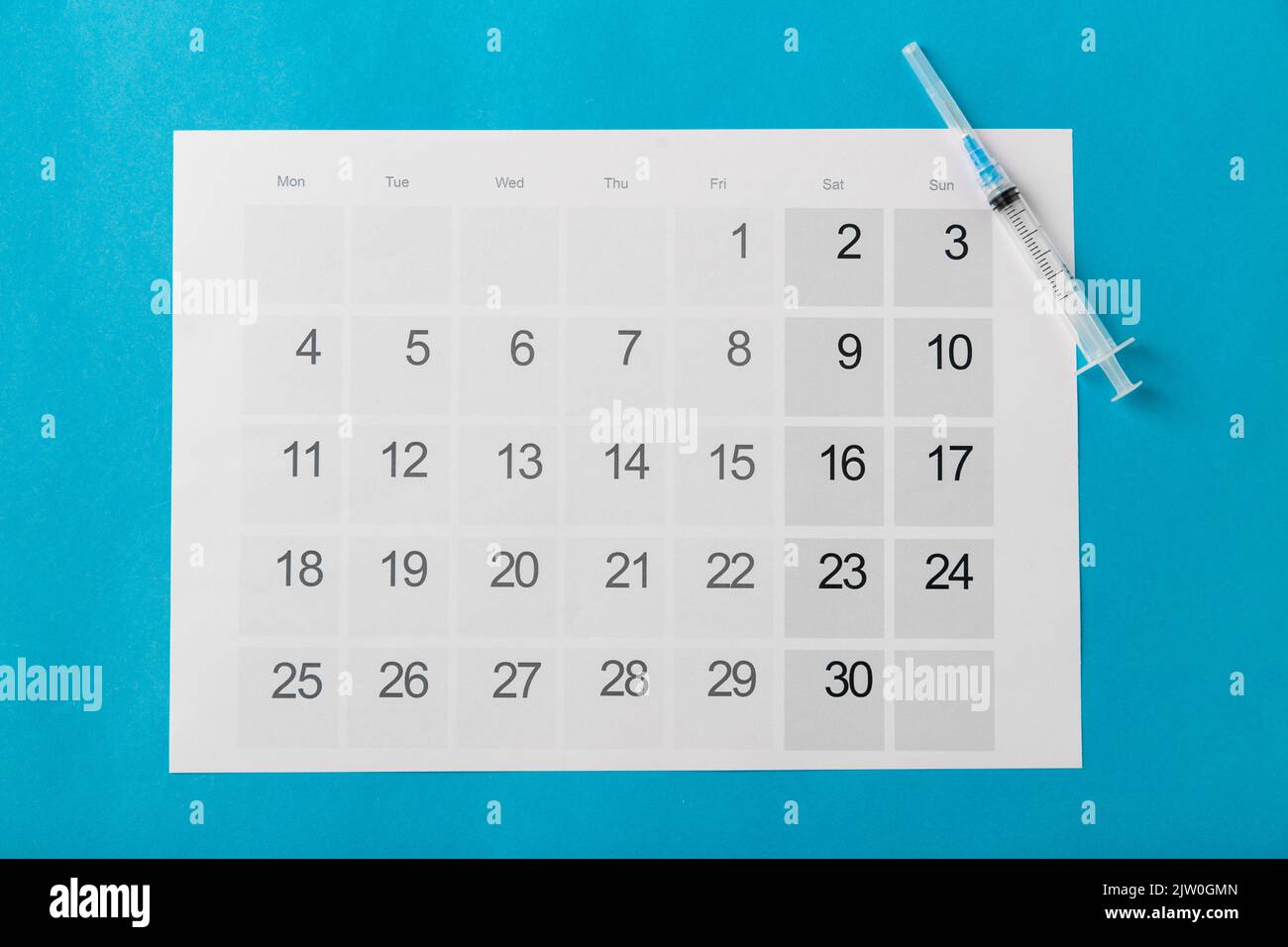 disposable syringe and calendar on blue background Stock Photo - Alamy