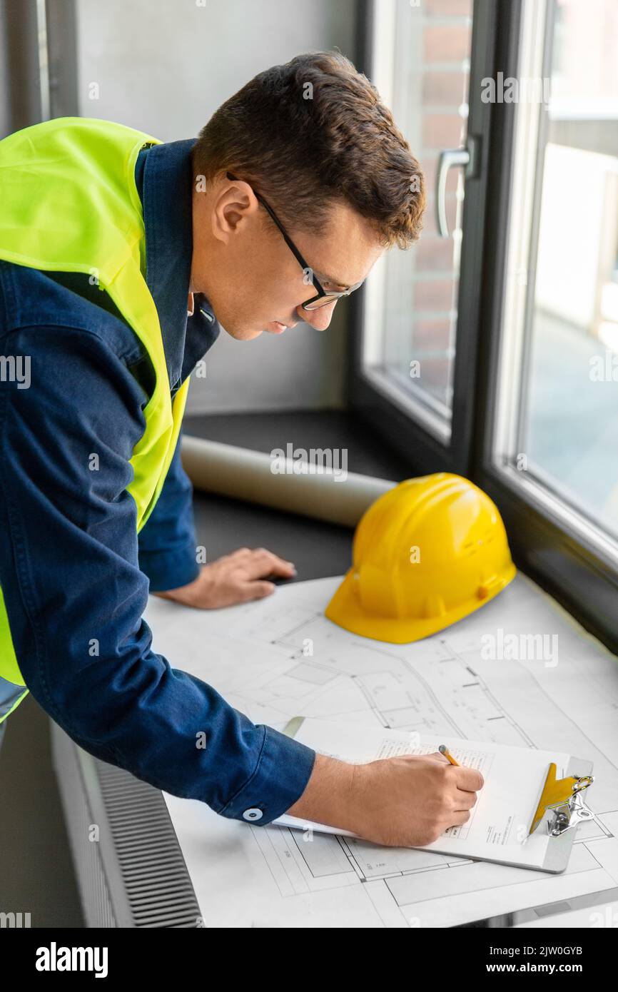 architect with blueprint and clipboard at office Stock Photo - Alamy