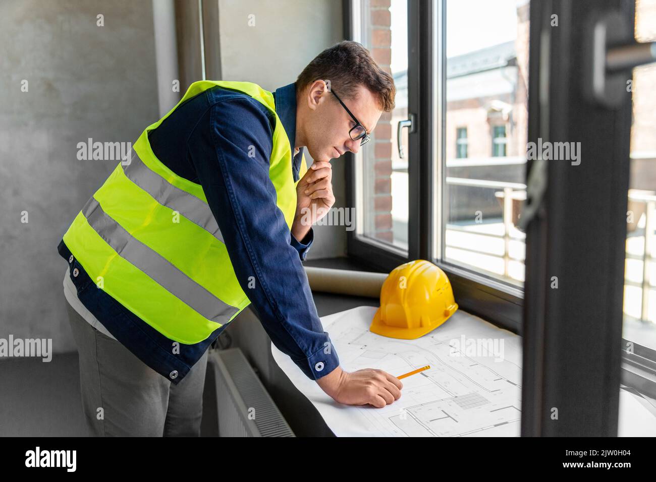 male architect with blueprint working at office Stock Photo - Alamy