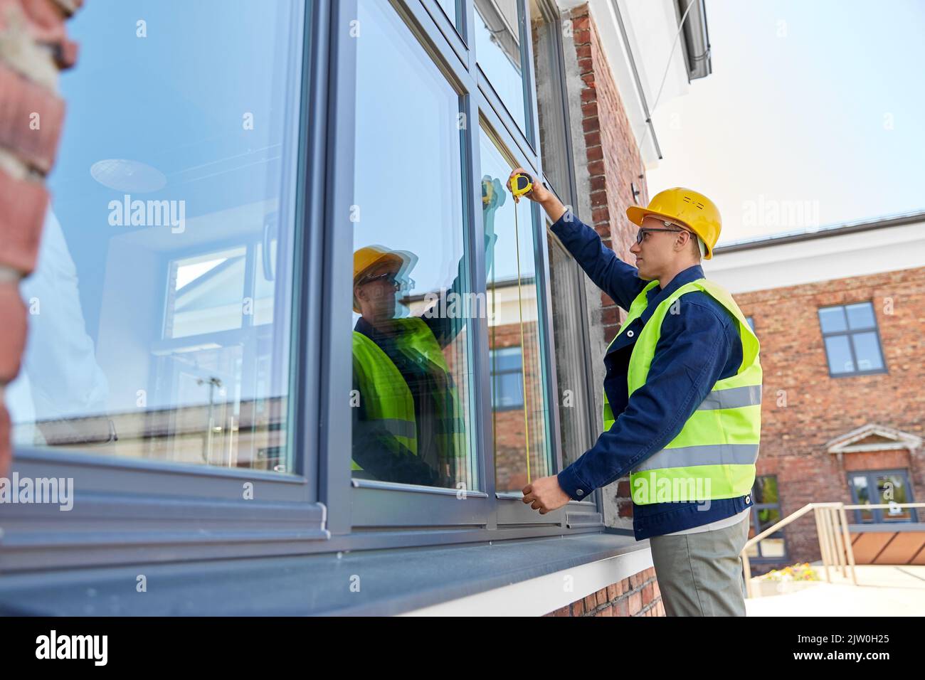 male builder with ruler measuring window Stock Photo - Alamy