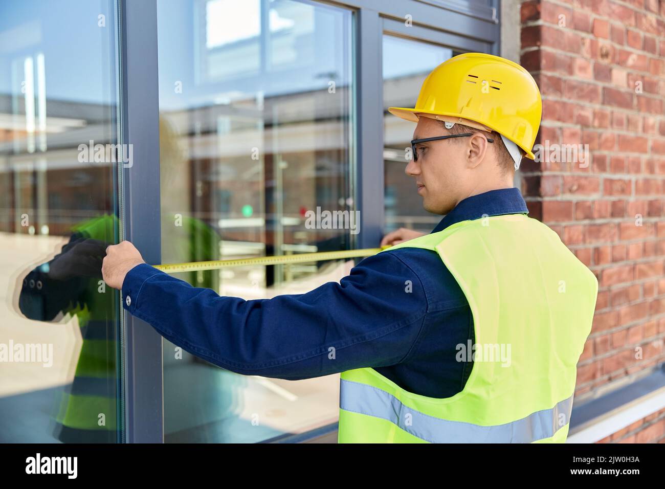 male builder with ruler measuring window Stock Photo - Alamy
