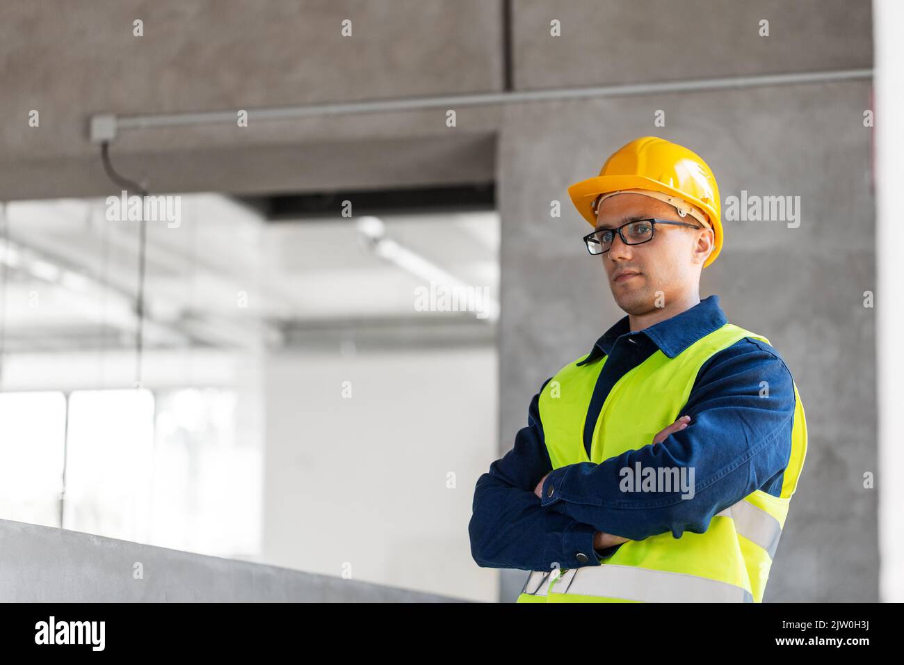 male builder in helmet and safety west at office Stock Photo - Alamy