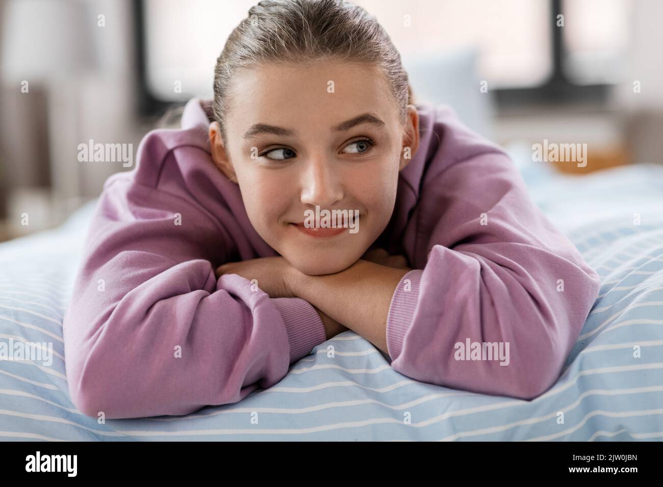 happy smiling girl lying on bed at home Stock Photo - Alamy
