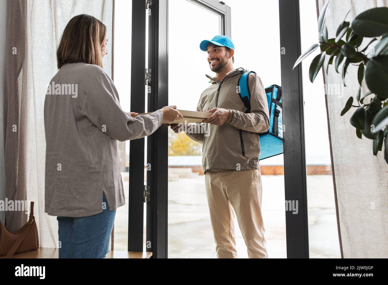 food delivery man giving order to female customer Stock Photo - Alamy