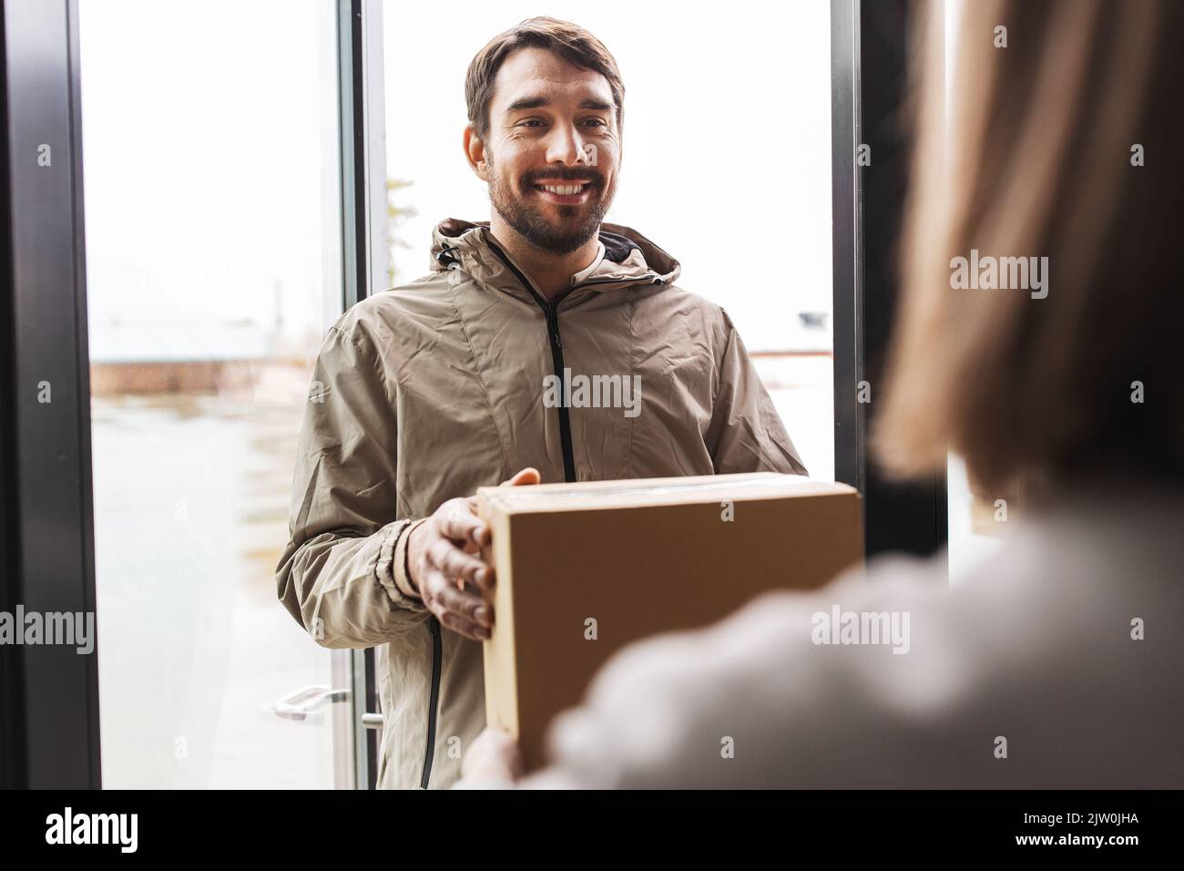 delivery man giving parcel box to customer at home Stock Photo - Alamy