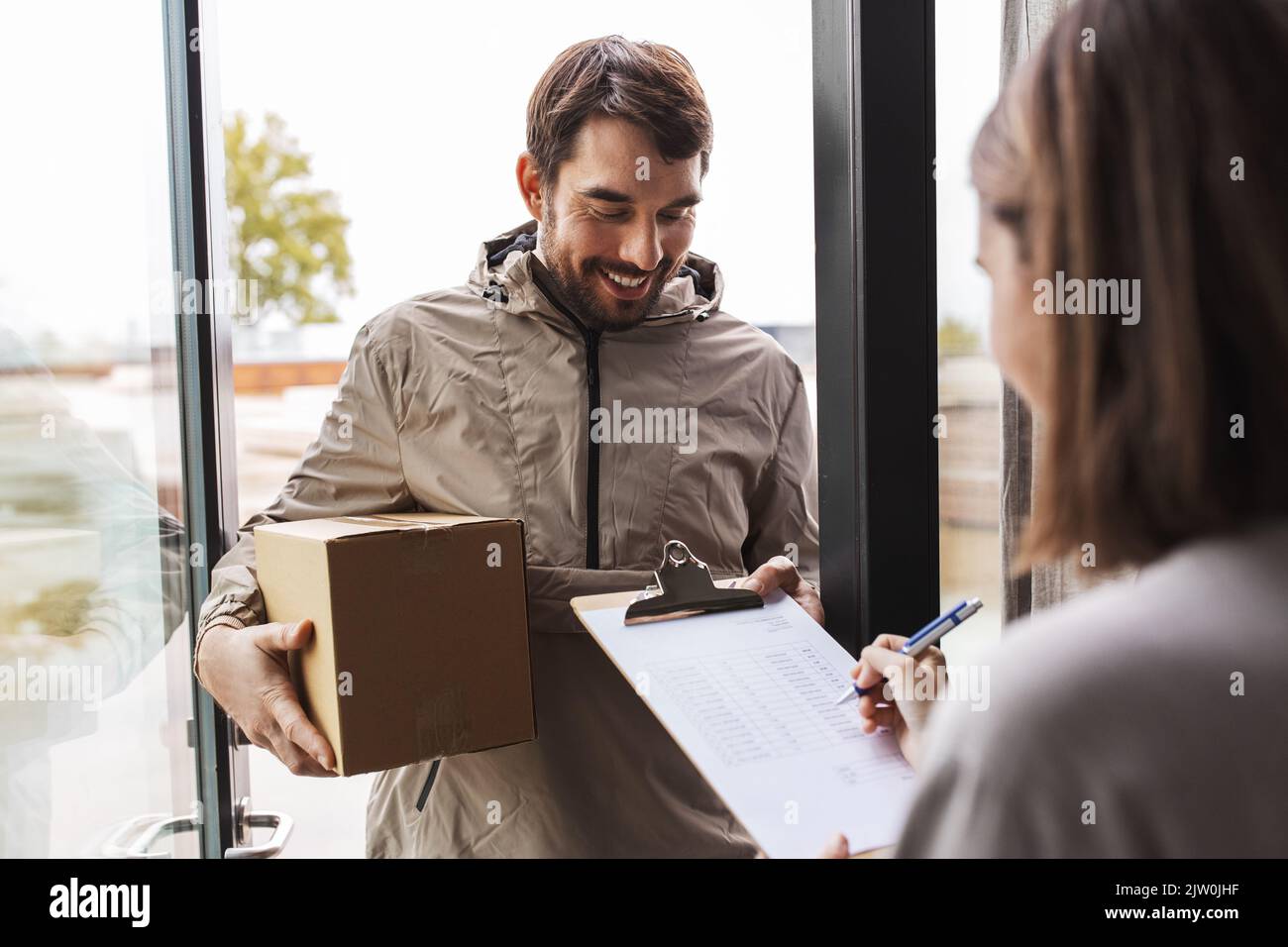 delivery man with parcel box and customer at home Stock Photo - Alamy
