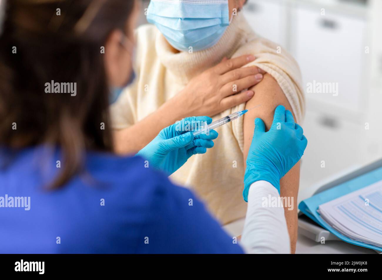 nurse with syringe making injection to woman Stock Photo - Alamy