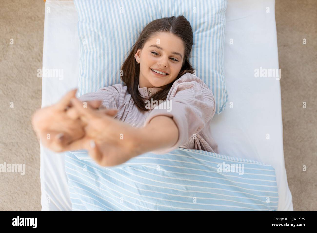 happy smiling girl stretching in bed Stock Photo - Alamy