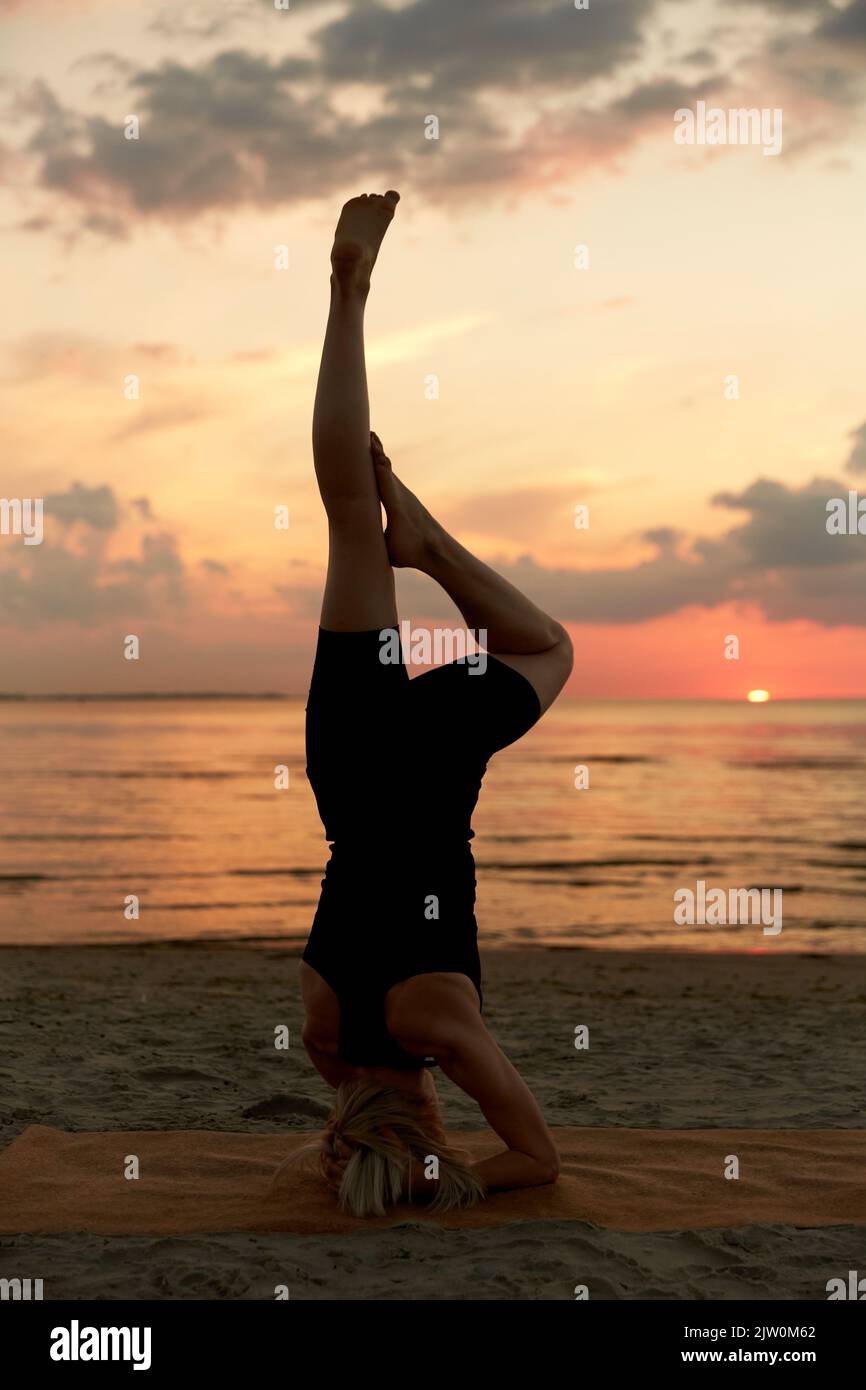 Woman doing headstand on beach hi-res stock photography and images - Alamy